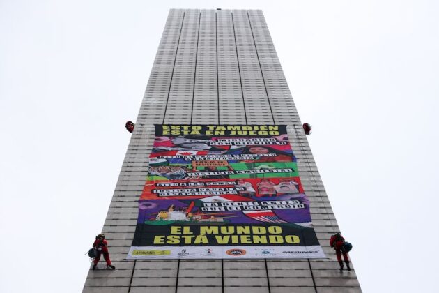 Activists climb a Mexico City monument in human rights protest